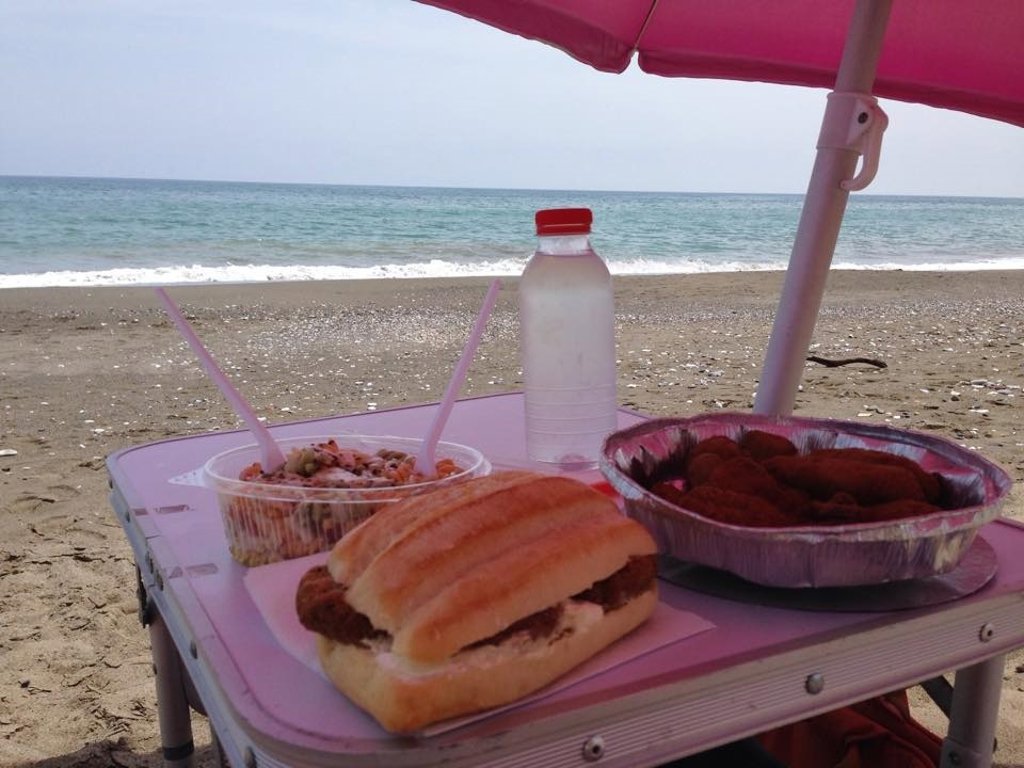 Un asador de pollos reparte comida casera en las playas de Málaga